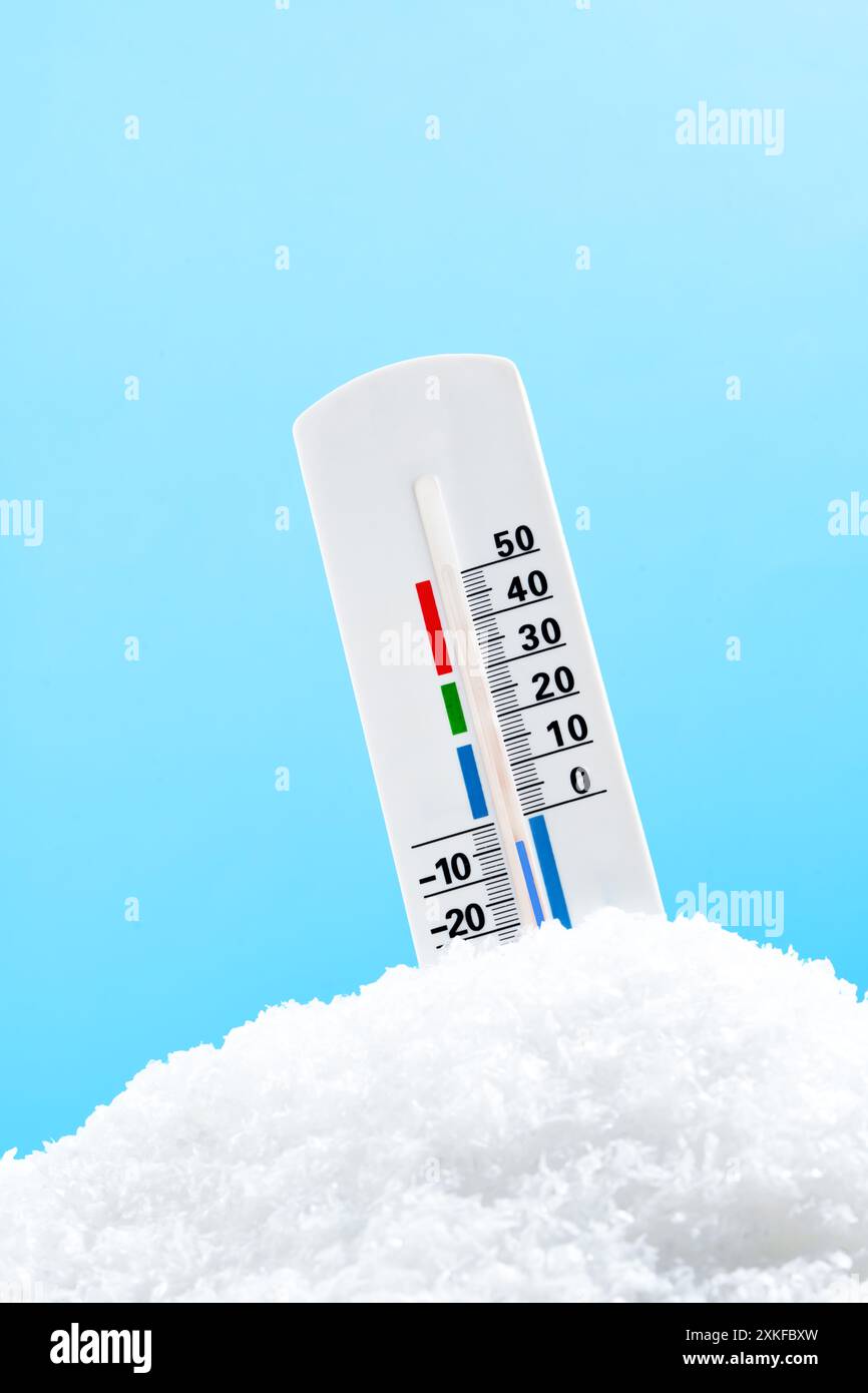 Thermometer Measuring Cold Temperature in Snow against blue background ...