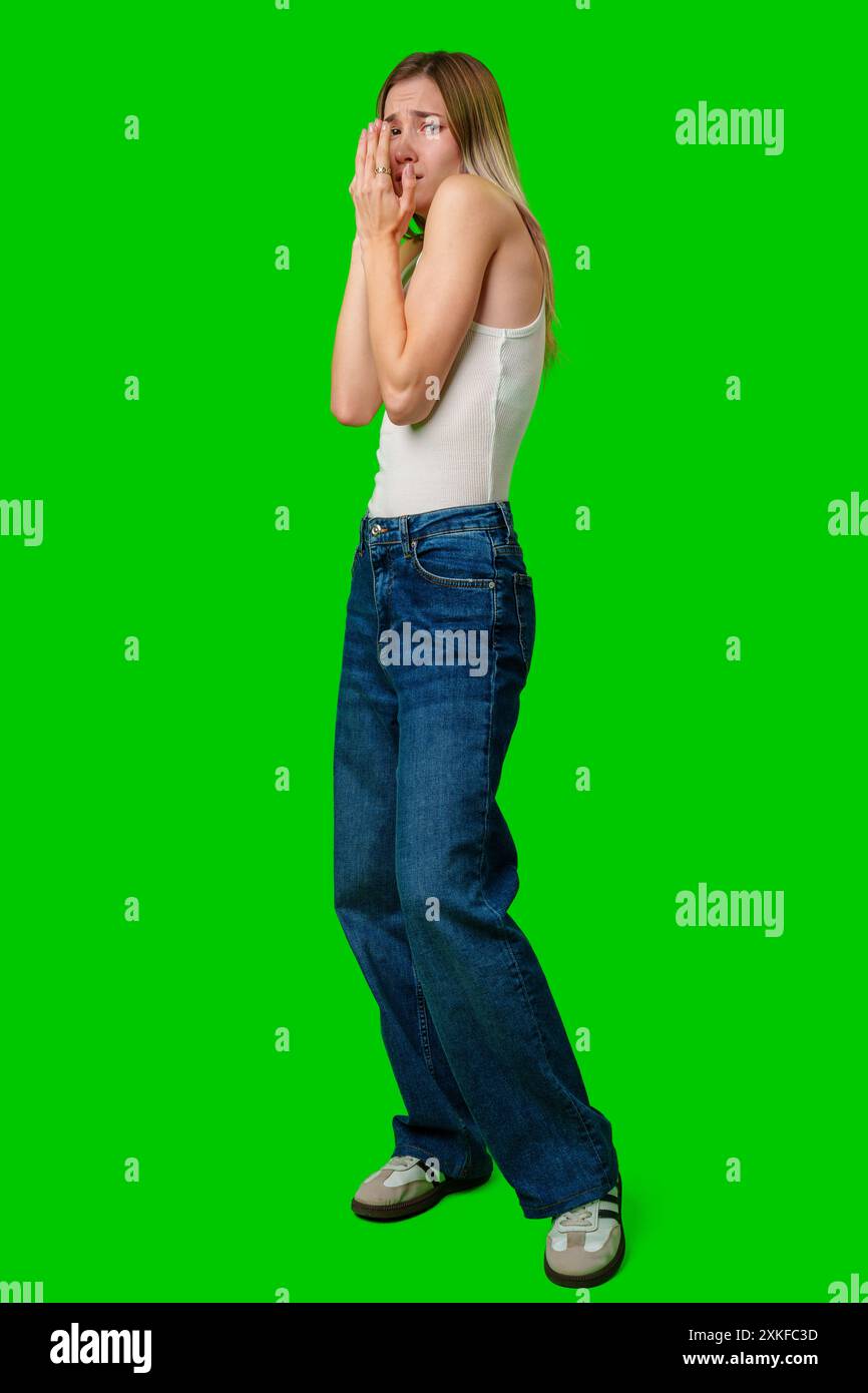 Woman in White Tank Top and Blue Jeans Posing With Hands Near Face ...