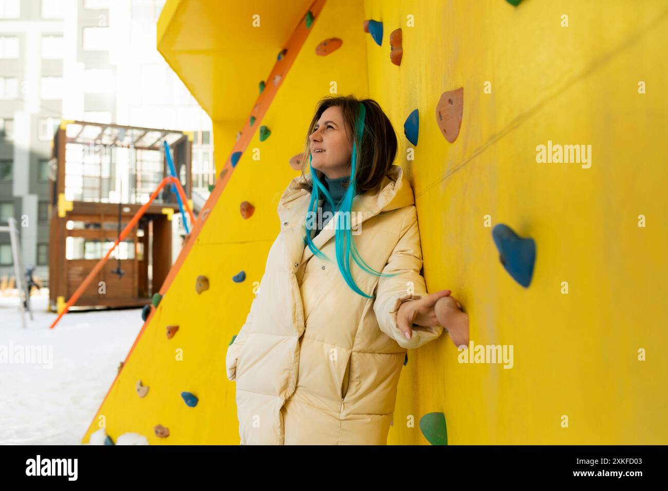 Woman Standing Next to Yellow Climbing Wall Stock Photo - Alamy
