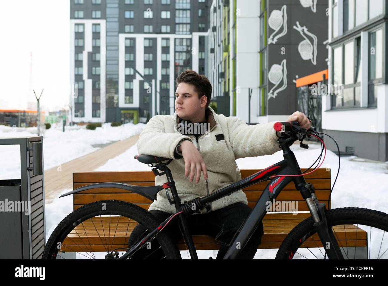 Cute young guy riding a bike around the city in winter Stock Photo - Alamy