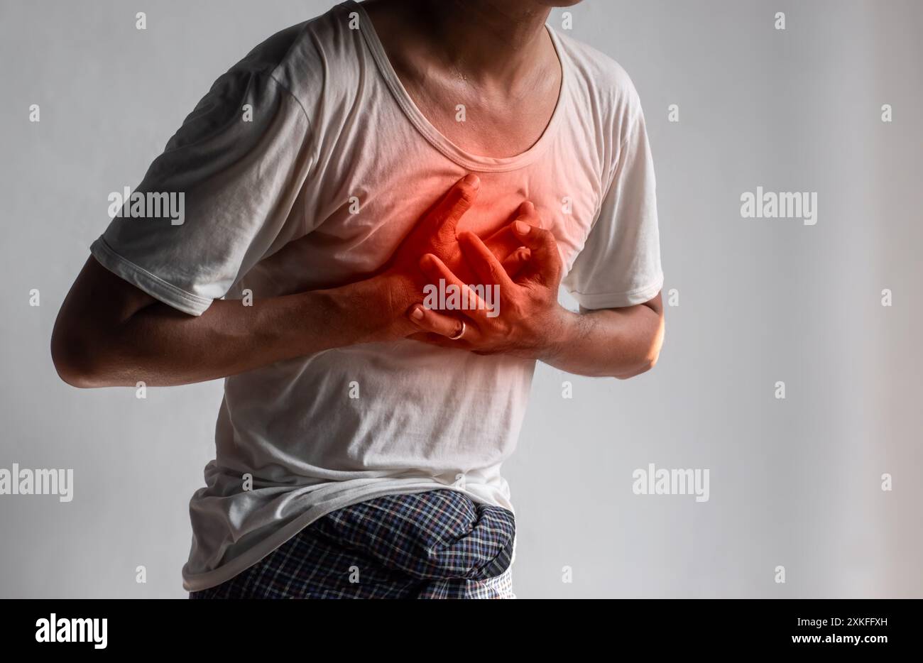 Asian young man suffering from central chest pain. Chest pain can be ...