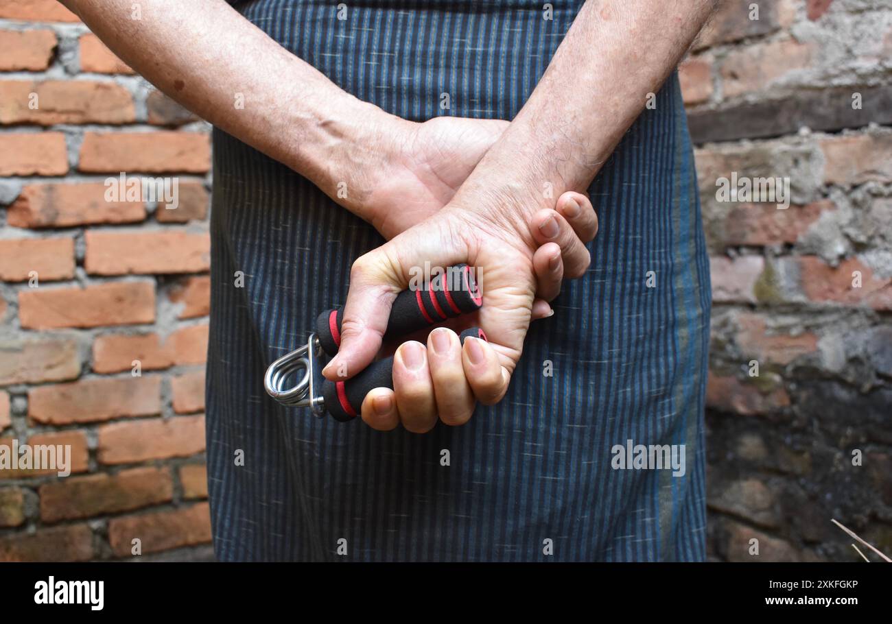 Southeast asian, Myanmar old man gripping hand exercise gripper Stock ...