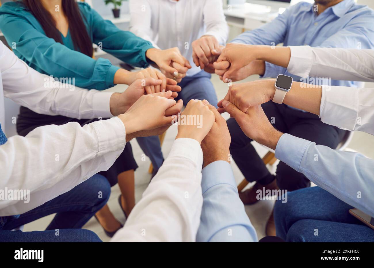 Close-Up Of Business People Holding Hands Together In A Circle Stock Photo - Alamy