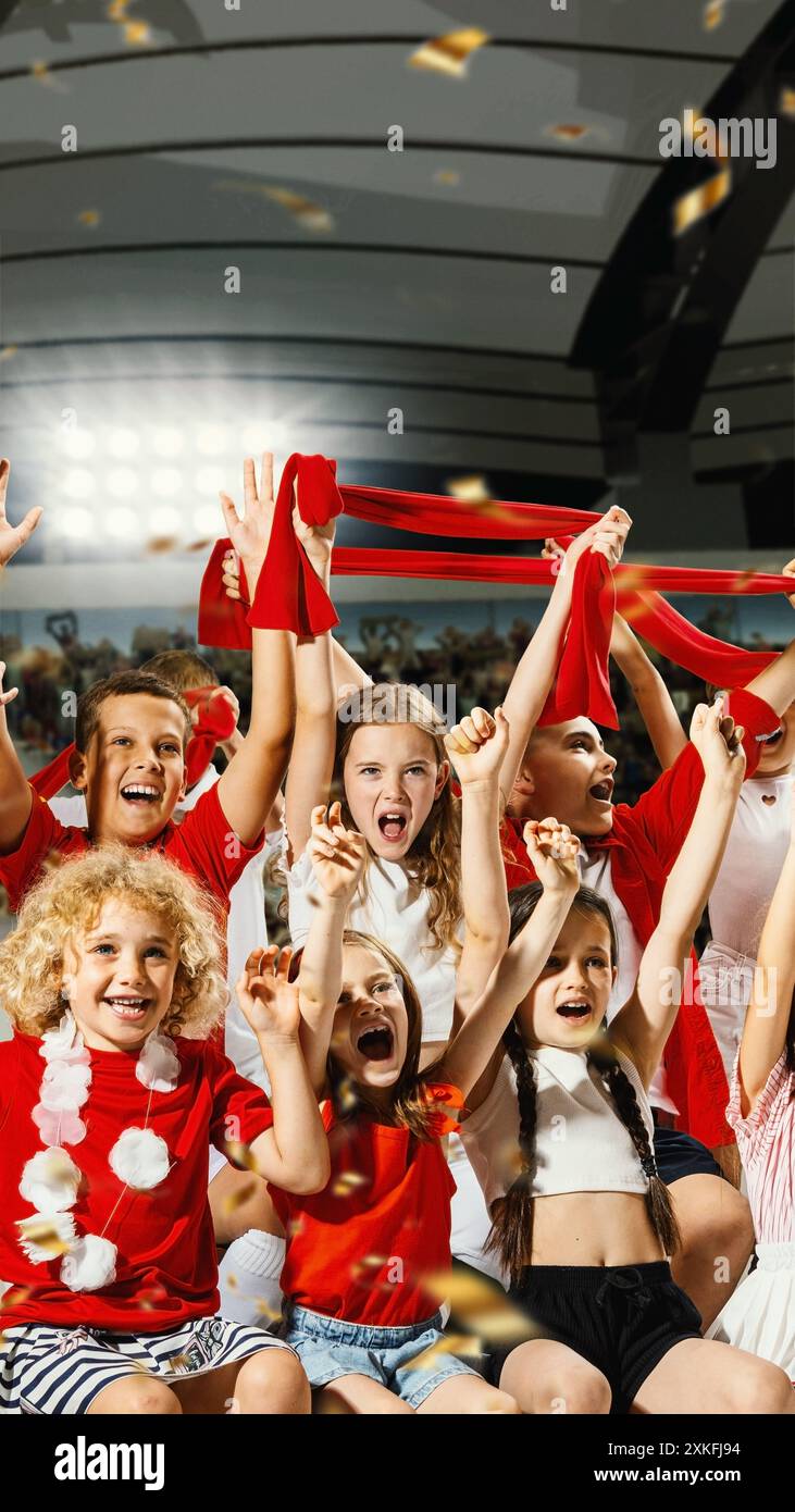 Jubilant children, dressed in red and white, enthusiastically wave red ...