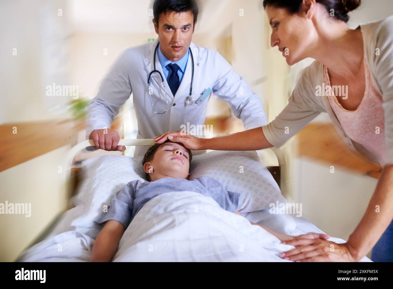 Rush, doctor and son with mother in hallway, emergency and wellness ...