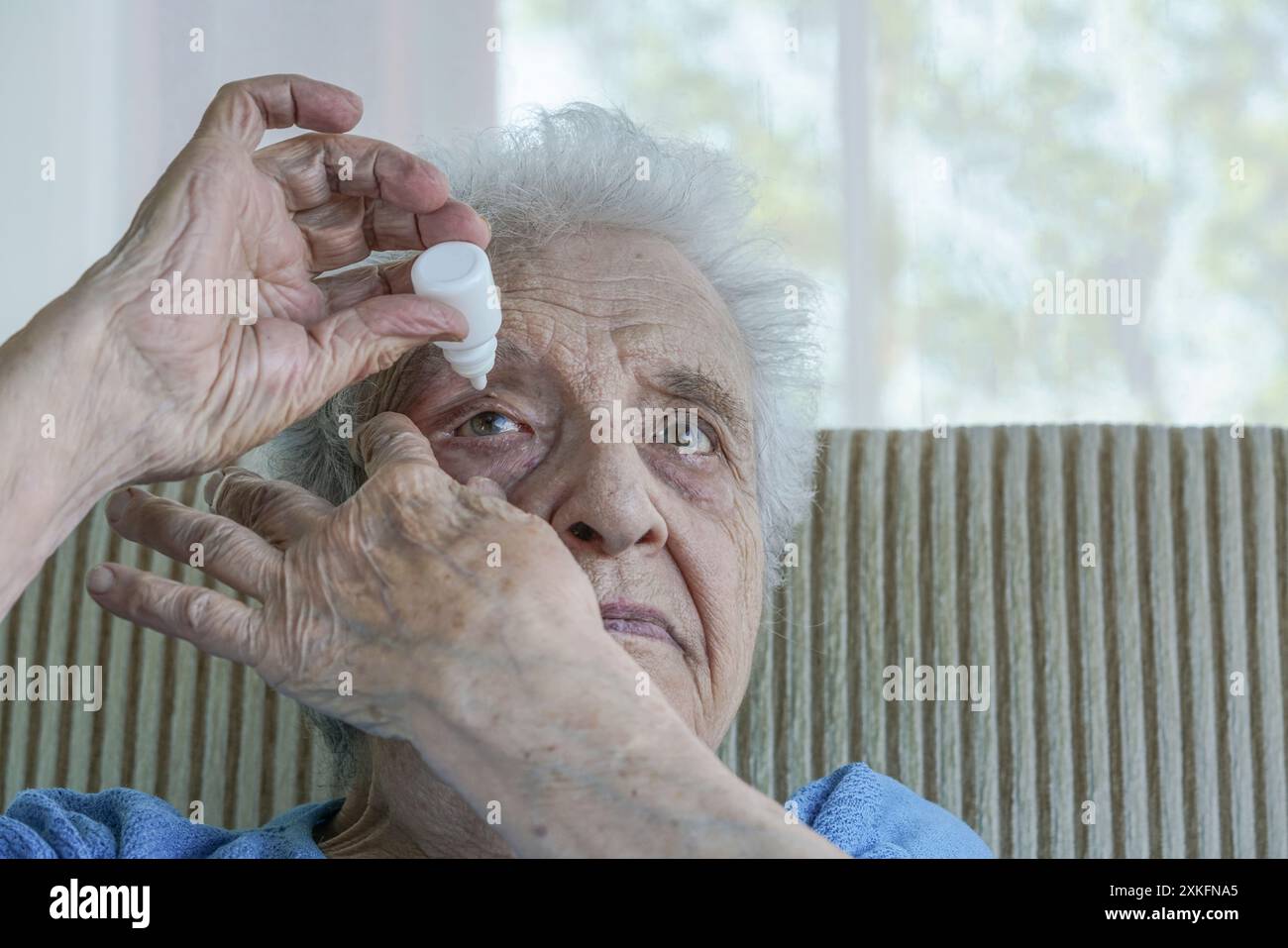 A senior woman applying eye drop by herself Stock Photo - Alamy