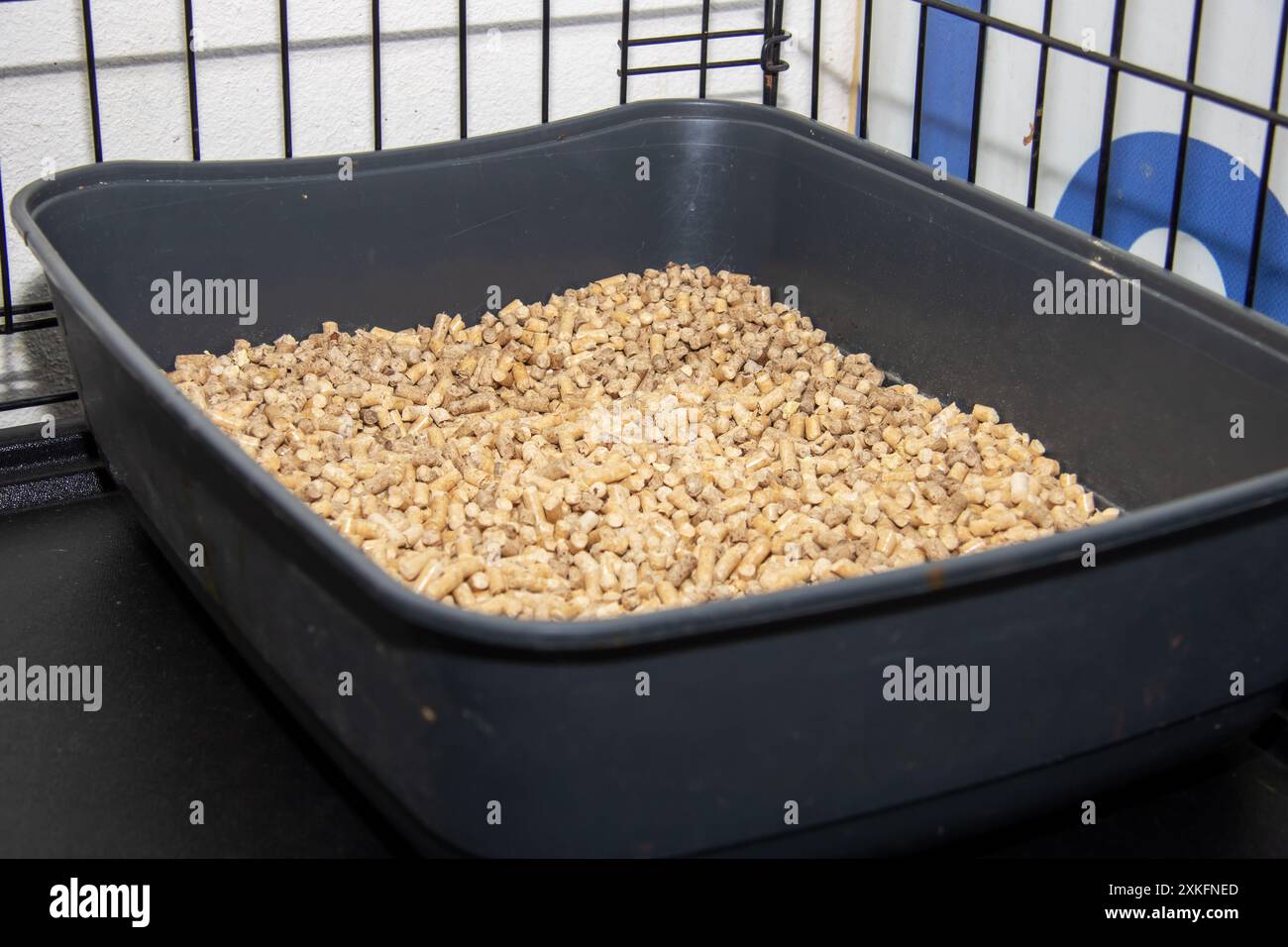 A litter box filled with wood pellets for pets, often placed in a home ...