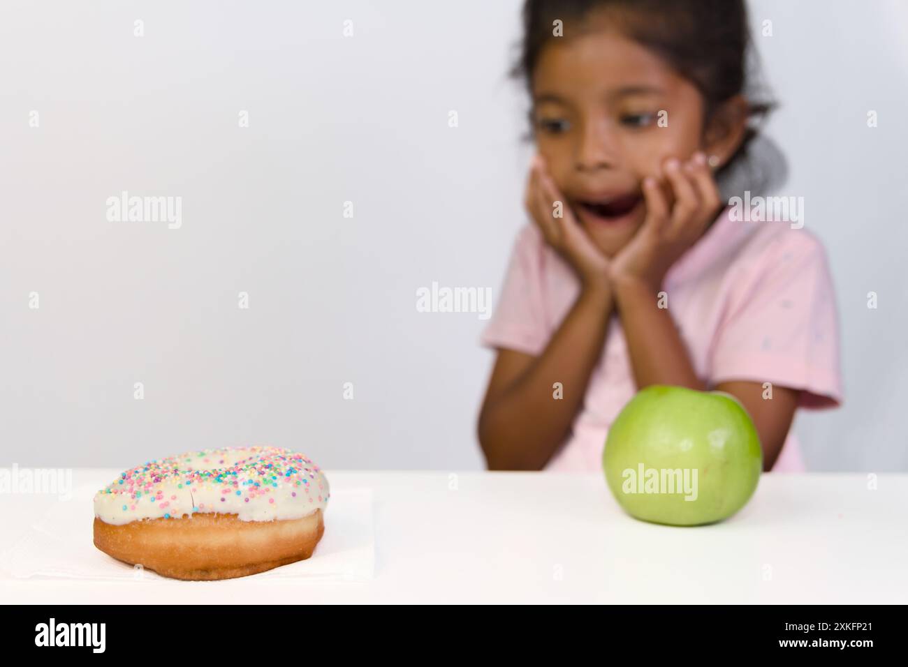 A young girl faces a delicious dilemma, choosing between a sweet treat ...