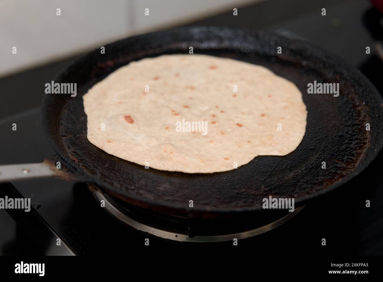 Traditional Indian flatbread, chapati, sizzling on a griddle. Home ...