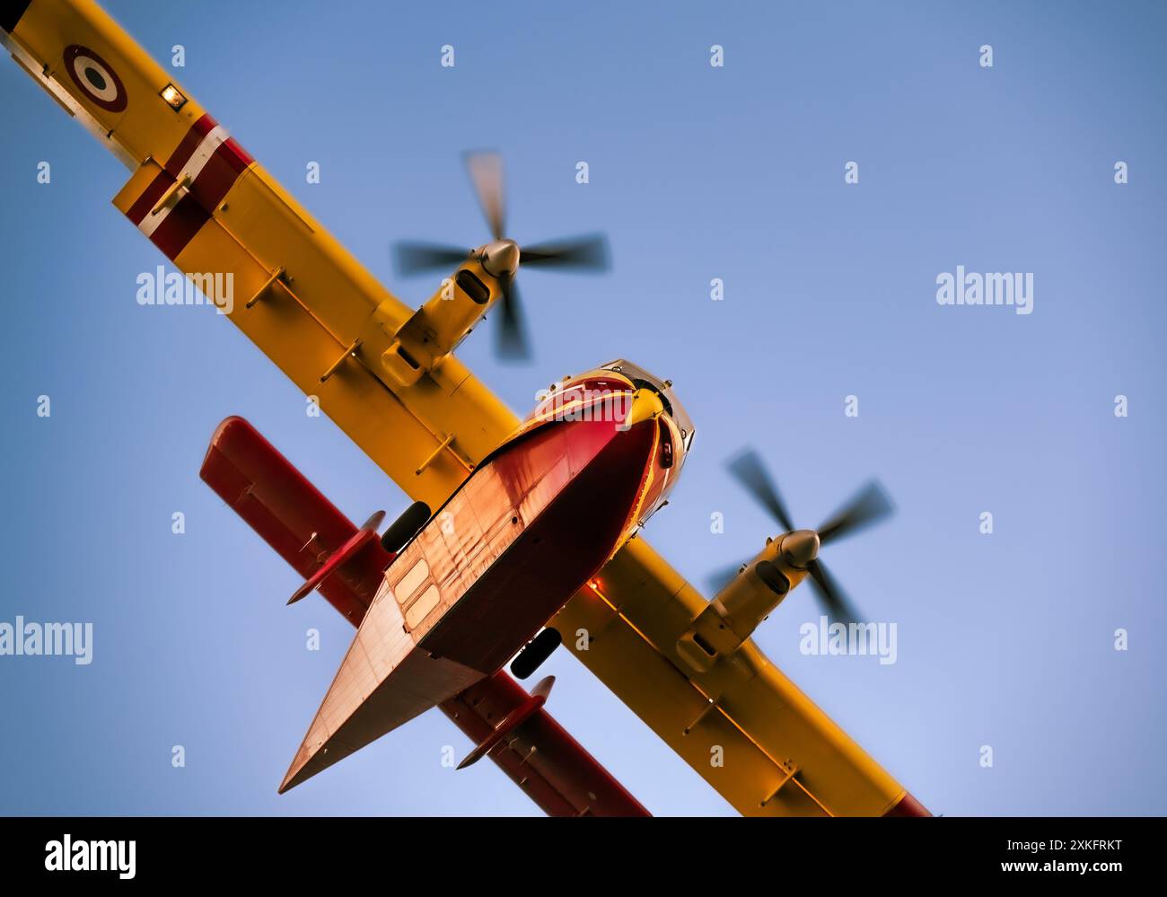 A firefighting aircraft is in action above a clear sky, engaged in ...