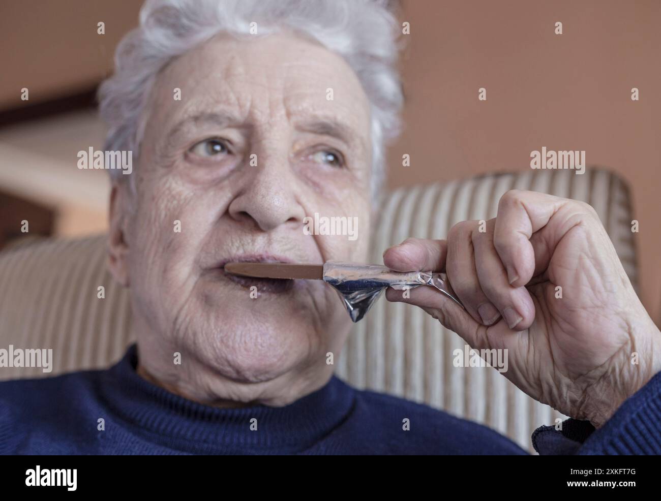 A lovely senior woman eating a chocolate bar Stock Photo - Alamy