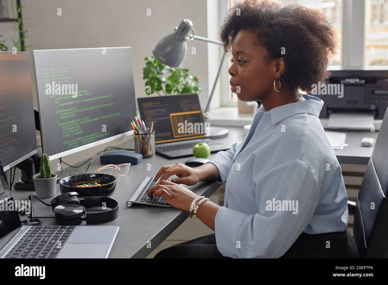 Side view of young African American female software developer using ...
