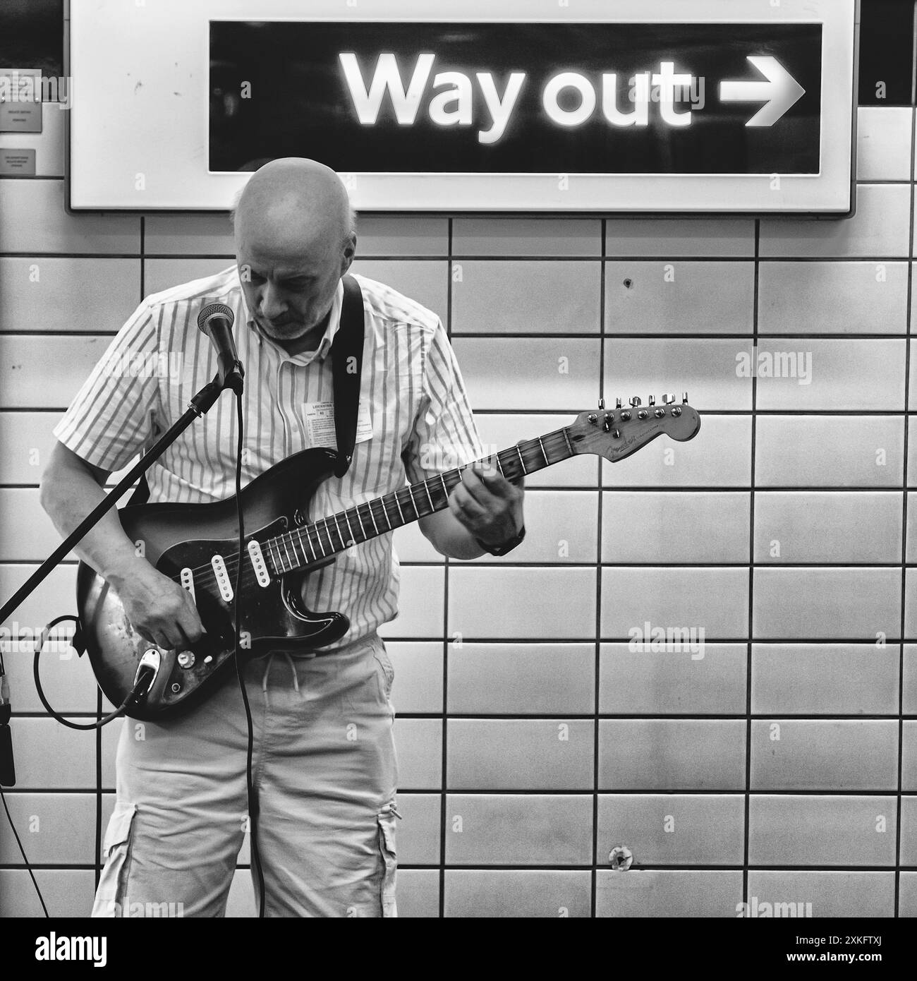 A busker performing on the London Underground by Way Out sign Stock ...