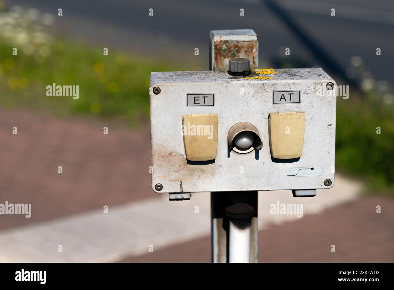 A close-up of a weathered white control panel with two buttons to ...
