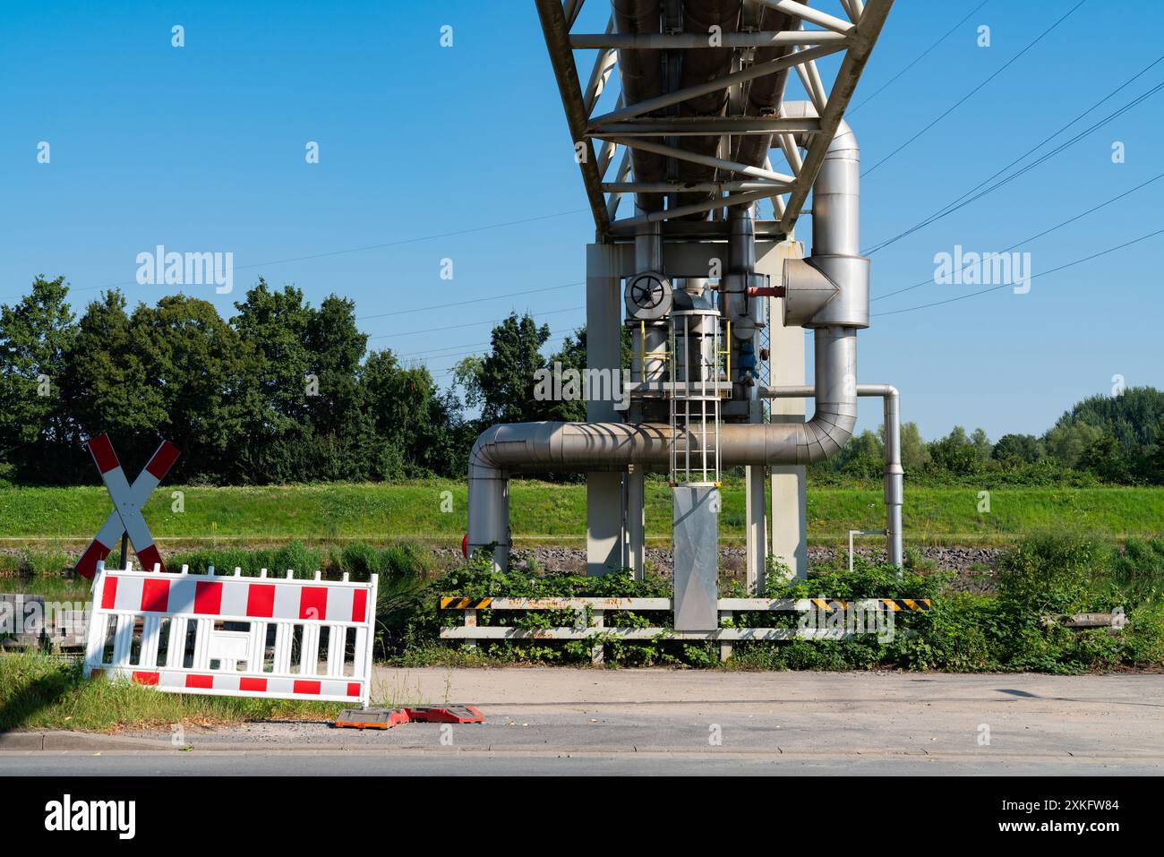 Red and white barrier near an industrial pipeline crossing. Made of ...