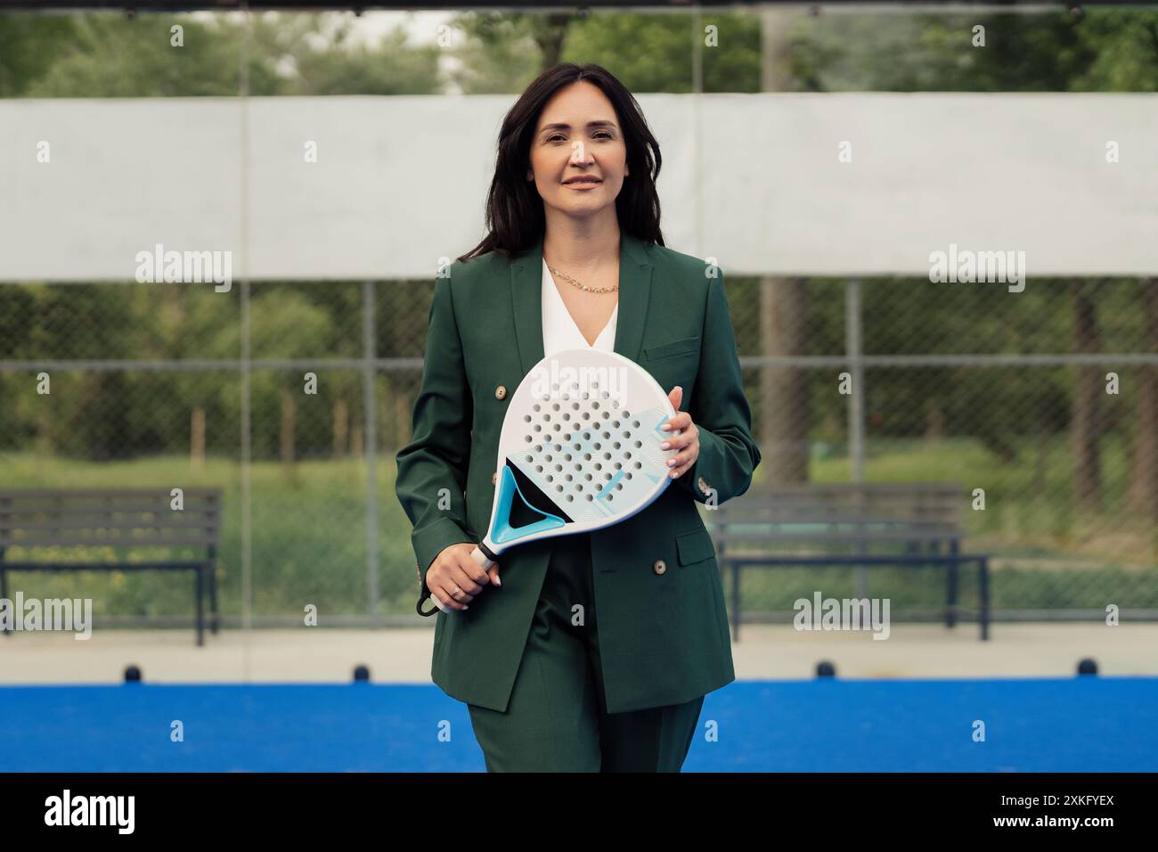 Confident woman in suit holding padel tennis racket on court Stock ...