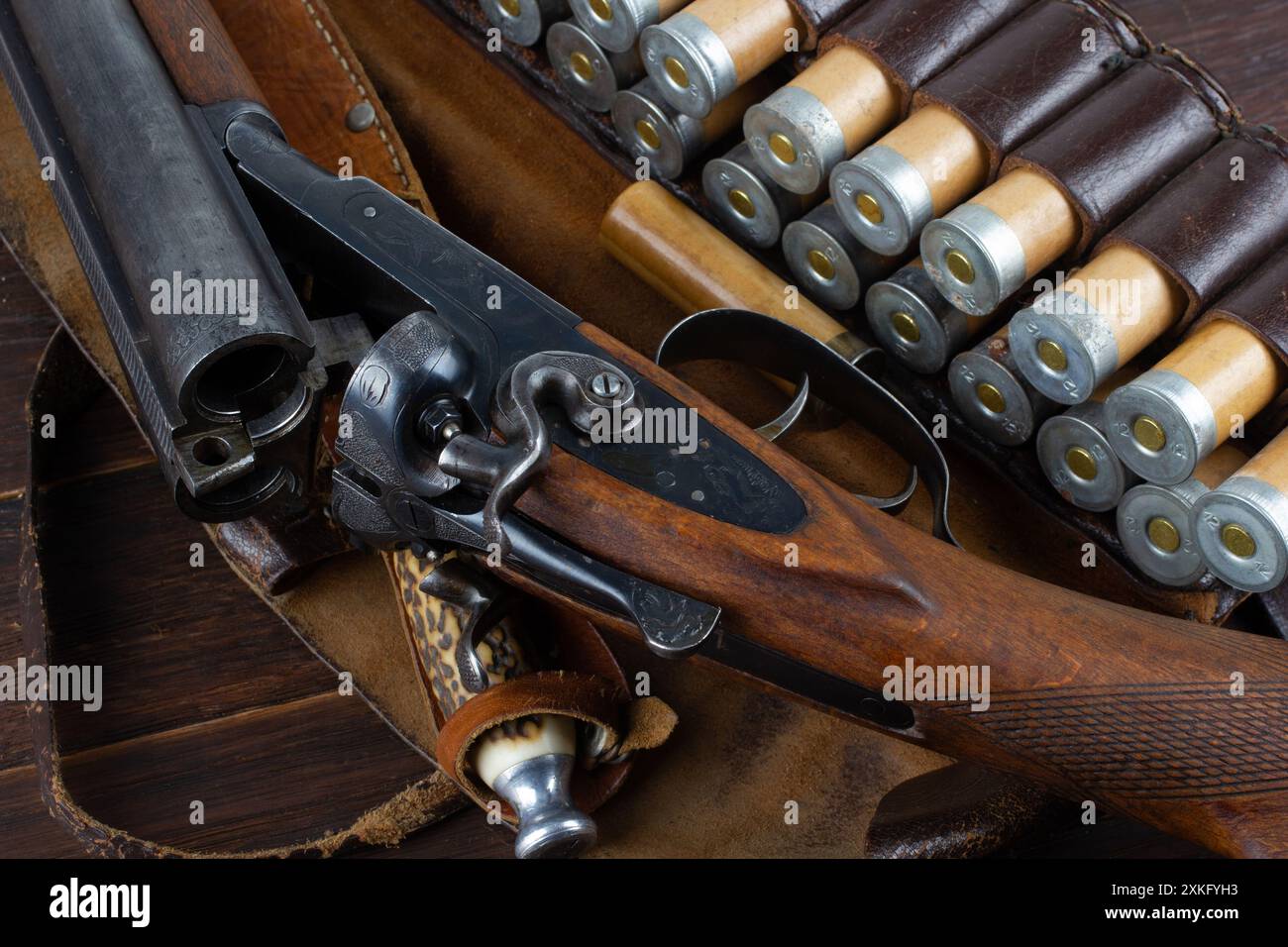 double barreled side shotgun with cartridges in bandolier on wooden ...