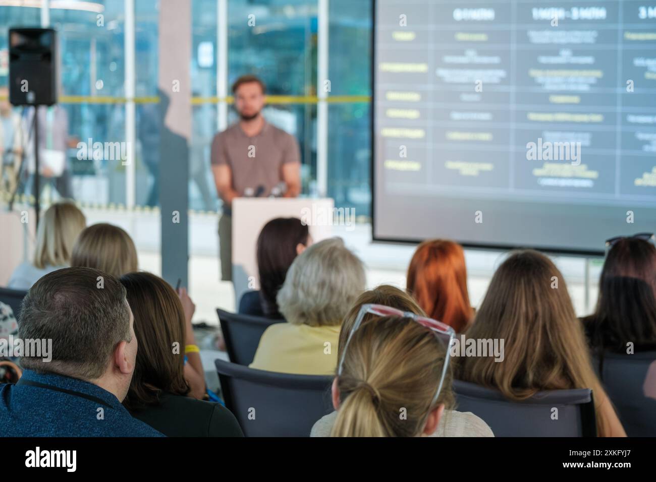 Business professional giving a presentation to an audience in a modern ...