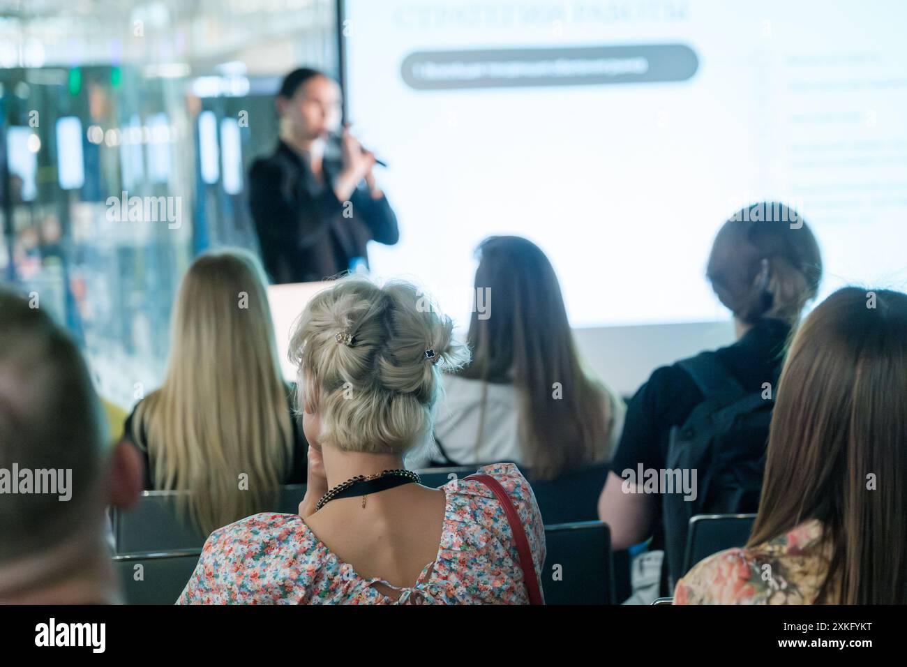 Speaker presenting to an engaged audience at a business conference ...