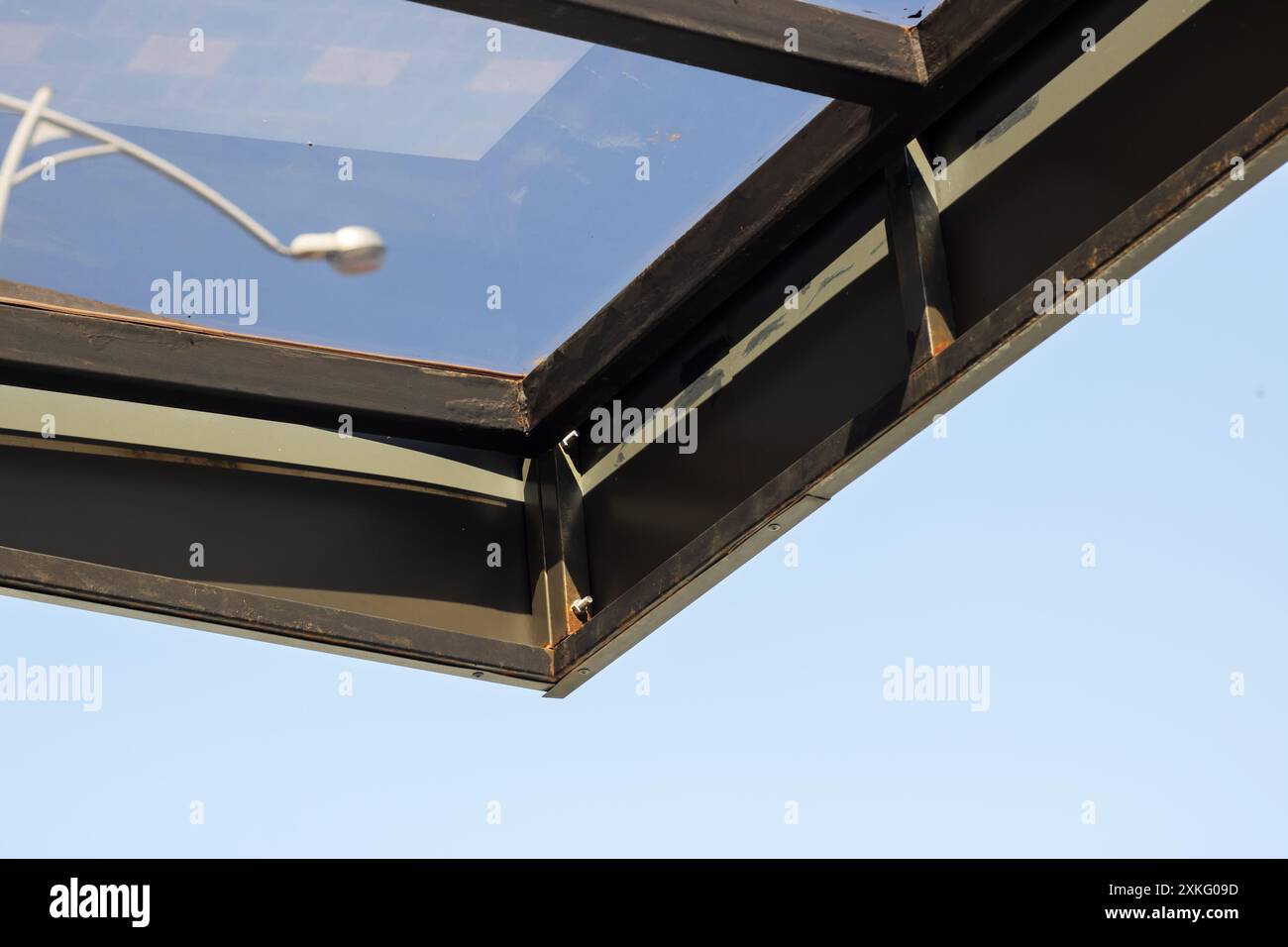 A street light is suspended from the roof of a building, casting ...