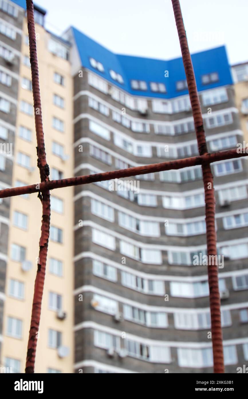 Skyscraper behind a barbed wire fence in a residential area, showcasing ...