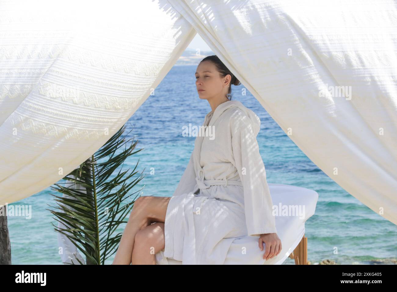 Woman waiting for treatment in spa tent on the beach. Massage gazebo ...