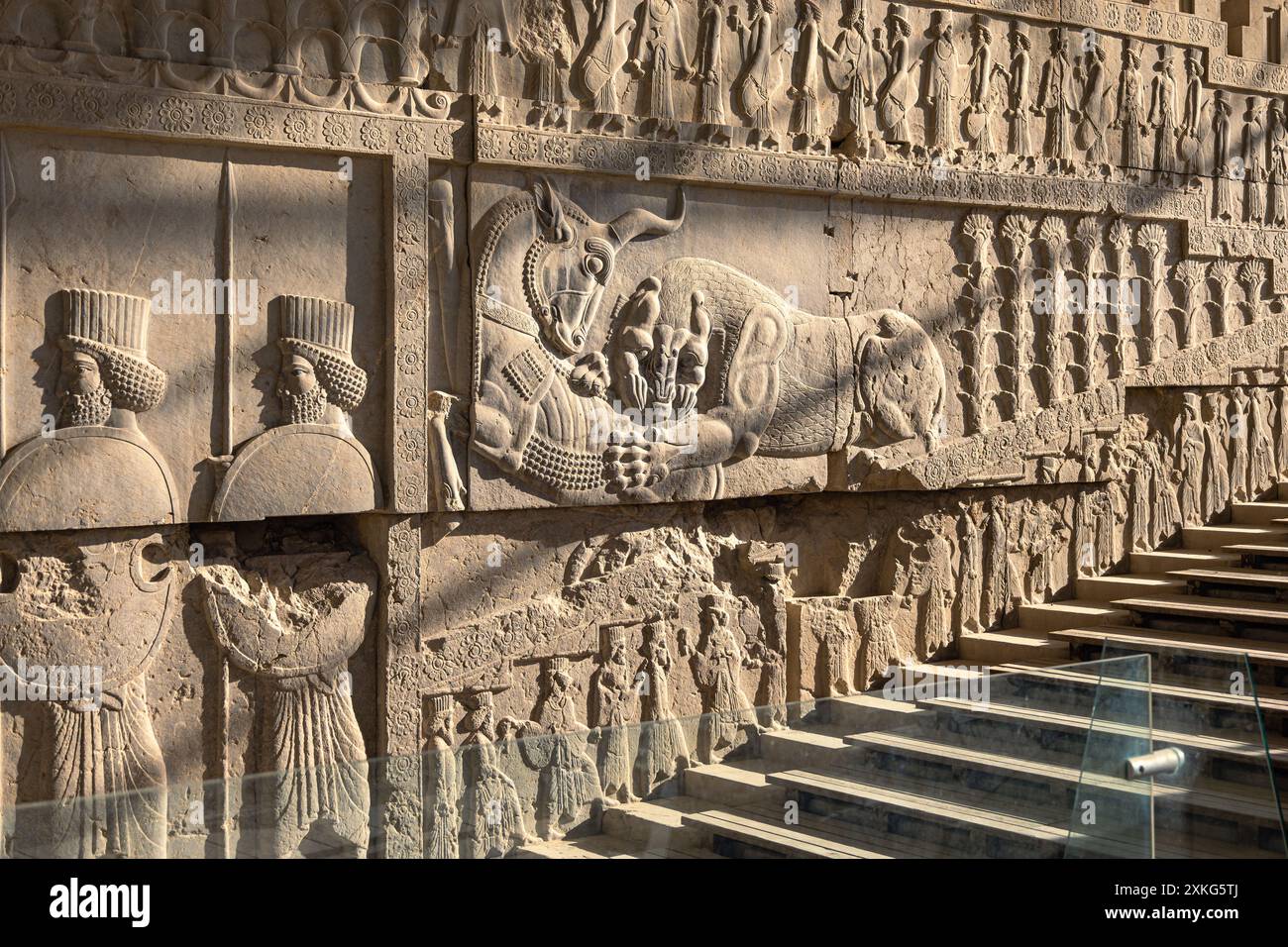 Relief carvings of a lion hunting a bull beside embossed soldiers on ...