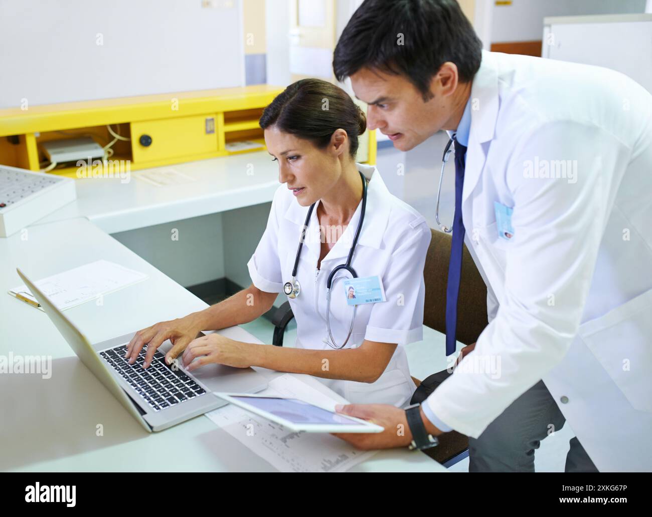 Doctor, nurse and checking laptop in reception, tablet and planning for ...