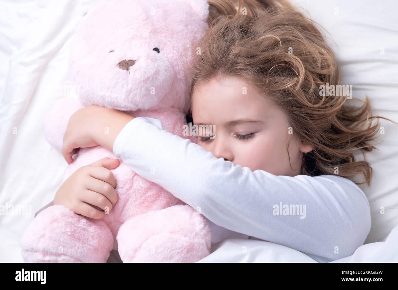 Good morning sleep. Little boy sleeping in bed with a toy teddy bear ...