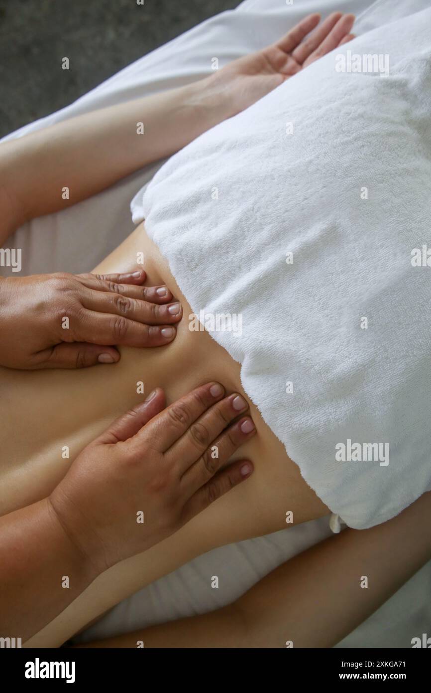 Back, neck and shoulder massage in the spa salon. Young woman receiving a luxurious oil massage ...