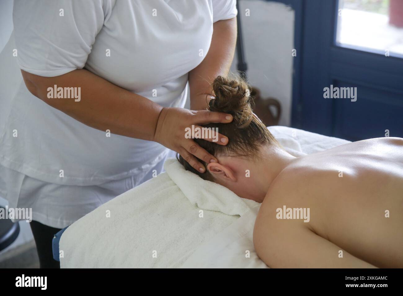 Back, neck and shoulder massage in the spa salon. Young woman receiving a luxurious oil massage ...