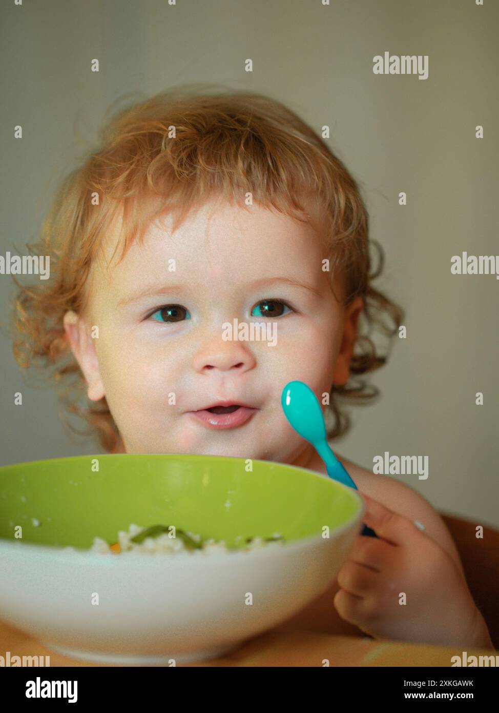 Kid baby eat soup in the kitchen with dishes and spoon Stock Photo - Alamy
