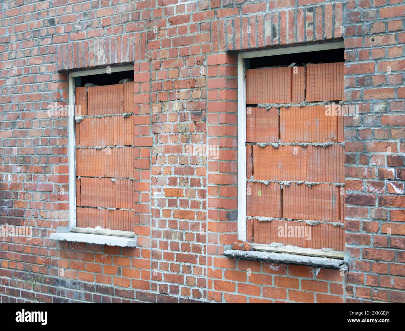 Walled up windows of an abandoned building. Exterior brick wall of an old house. Weathered and ...