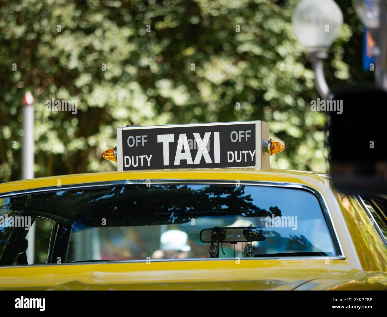 Taxi Off Duty sign on an old American cab. Yellow car parking outdoors ...