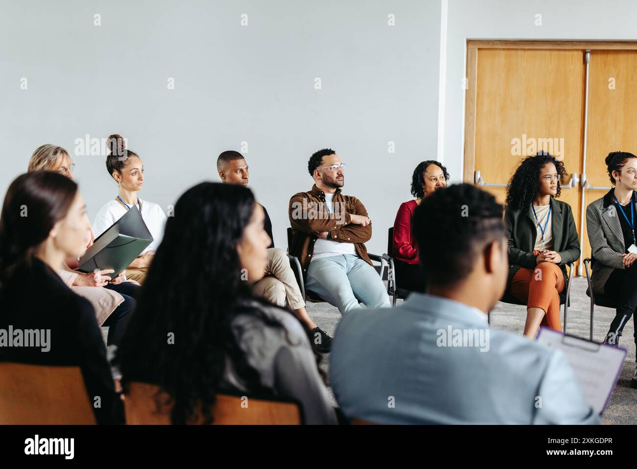 A diverse group of professionals attentively participating in a ...
