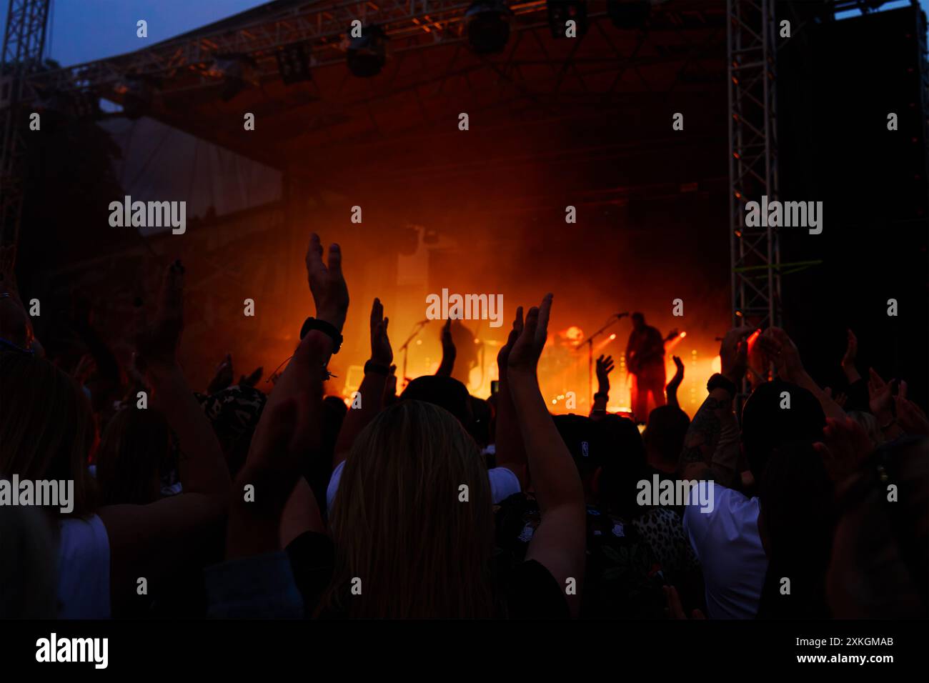 Silhouettes of crowd at concert in front of stage with bright ...