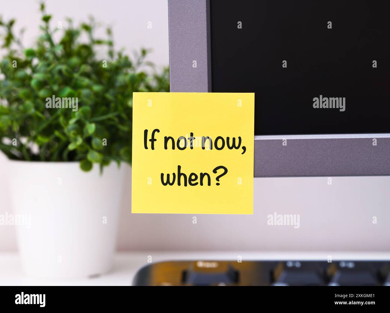 A yellow paper note with words If Not Now, When? sticked on to a ...