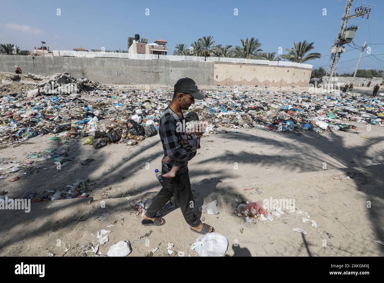 Palestinians walks near tents used as shelter along a street covered ...