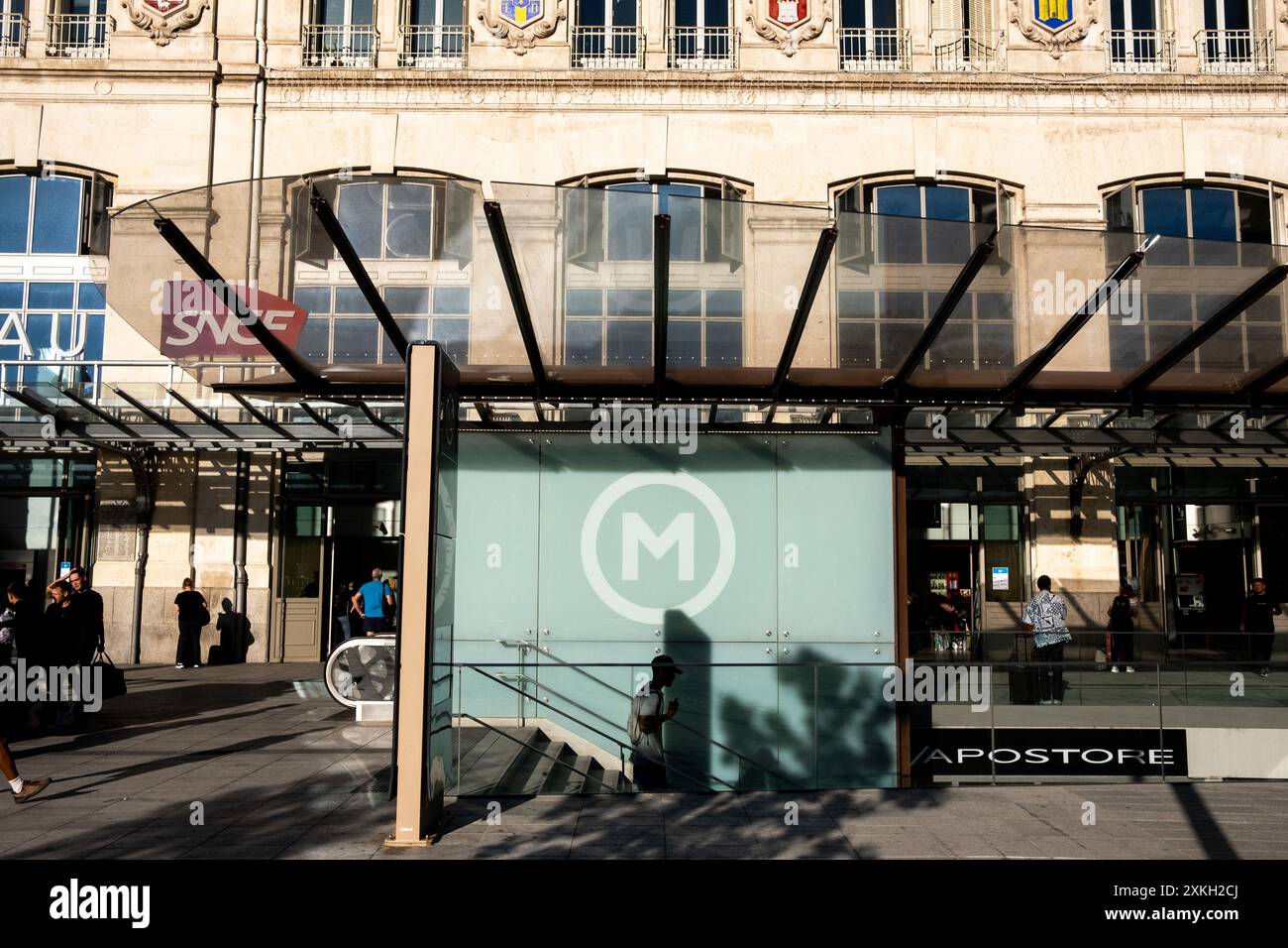 Sign indicating the entrance to the metro in front of the facad of ...
