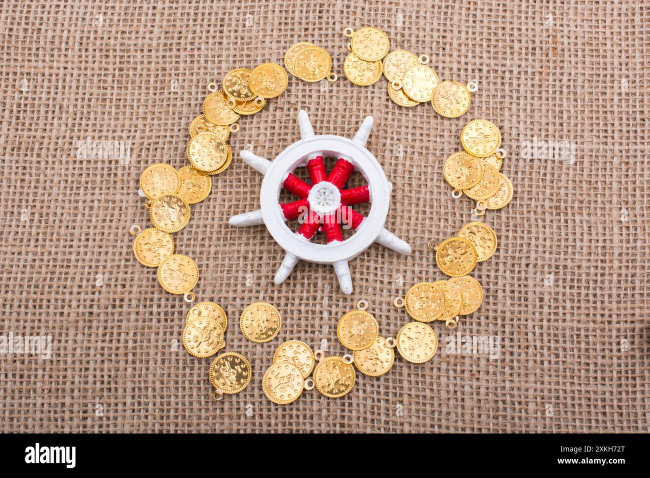 Fake gold coins around the little steering wheel Stock Photo - Alamy