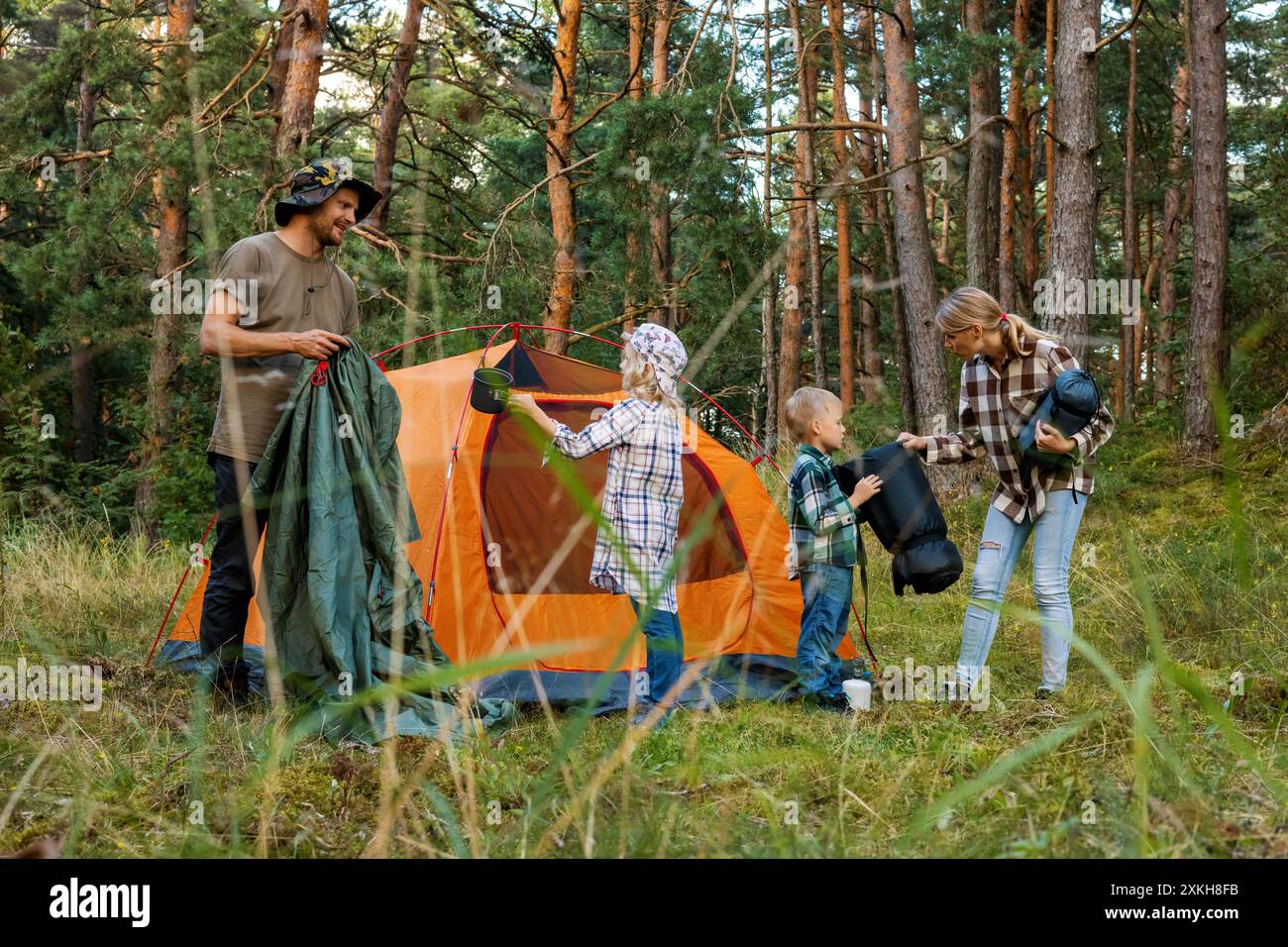 family camping at forest. setting up tent. outdoor adventure with kids ...