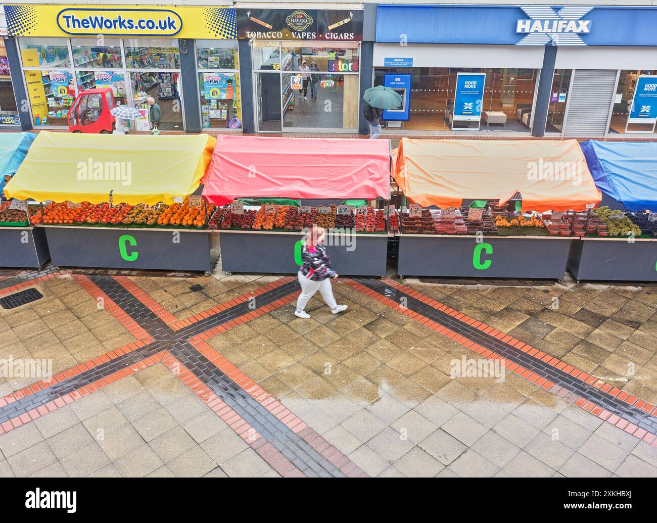 Fruit market stalls on Corporation Street on a rainy day in Corby town ...