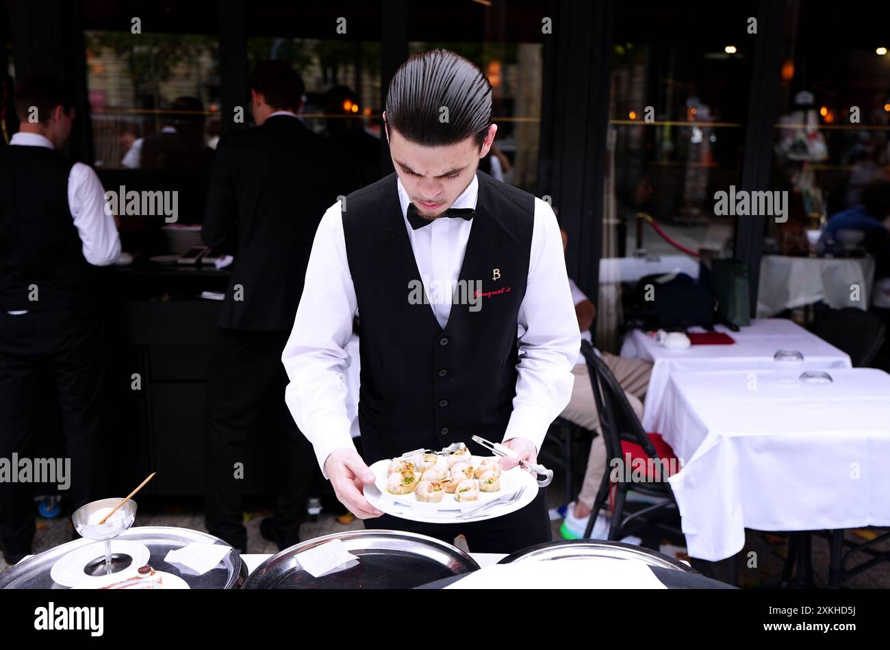 A waiter on the Champs-Elysees, Paris. The Opening Ceremony of the ...