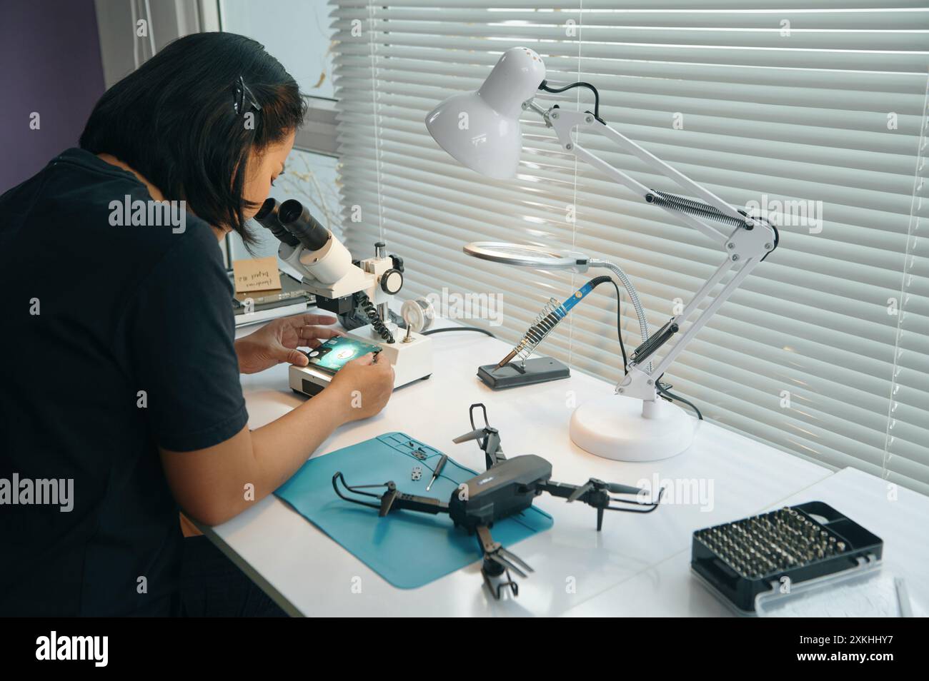 Master Examining Details Of Drone In Microscope Stock Photo - Alamy