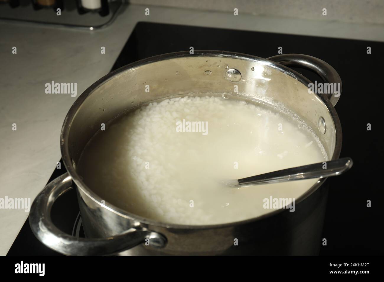 Boiled rice in pot on induction stove, closeup Stock Photo - Alamy