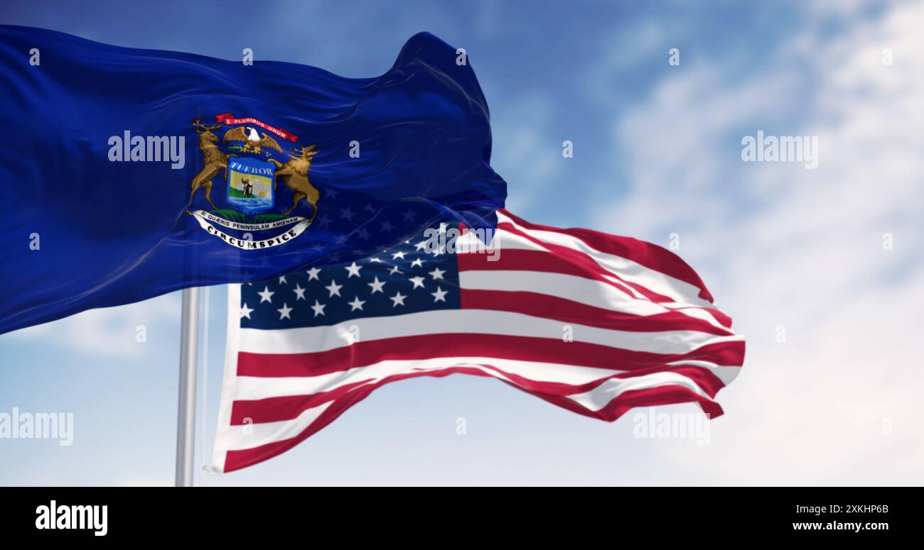 Michigan state flag and national american flag waving in the wind on a ...