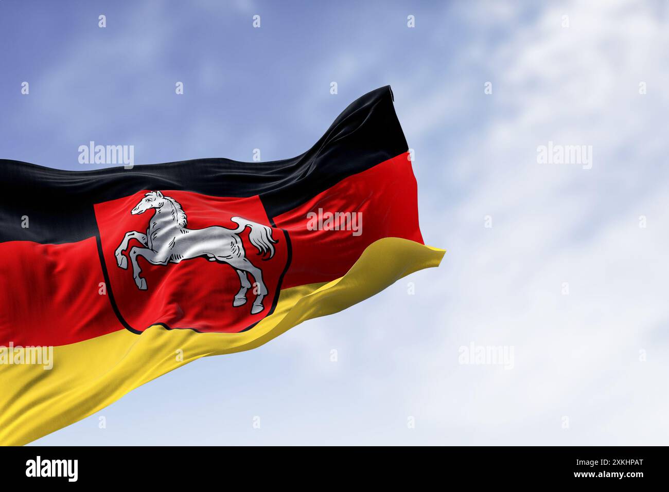 Lower Saxony state flag waving on a clear day. Black, red and yellow ...