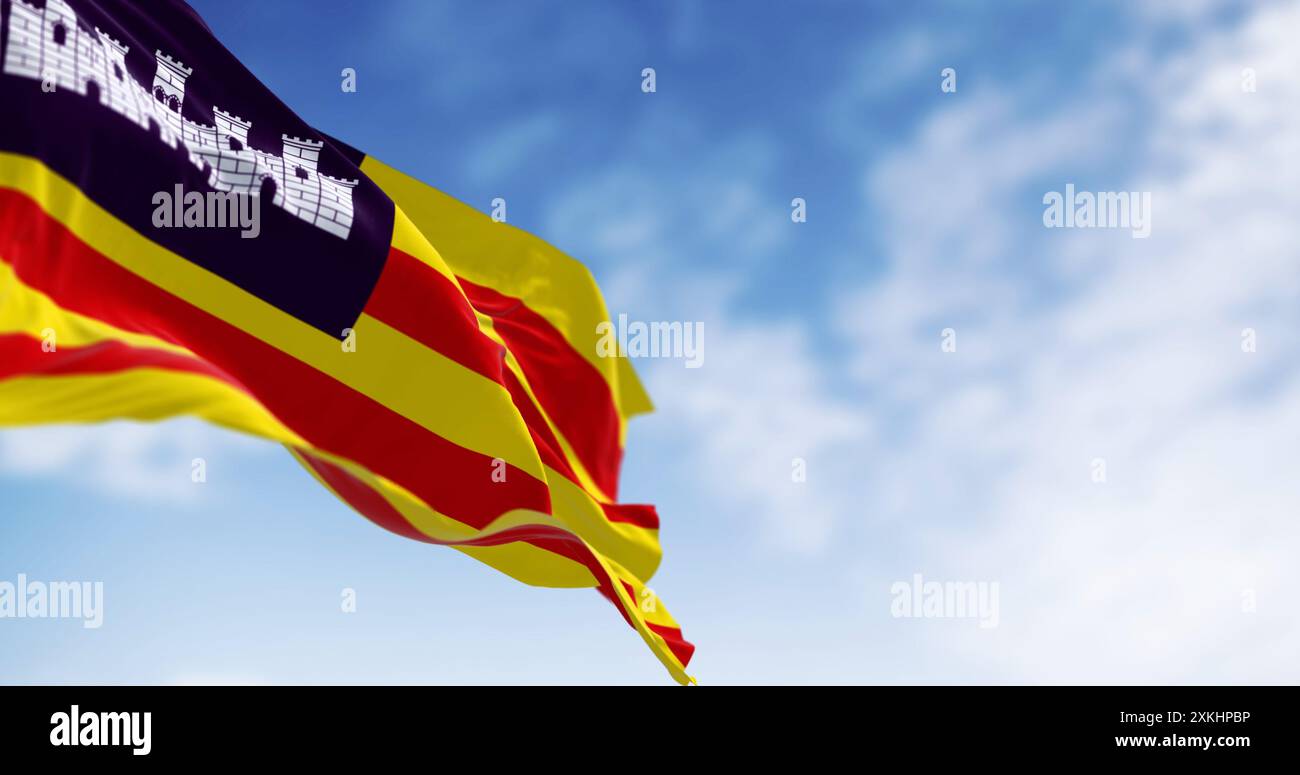 Balearic Islands flag waving in the wind on a clear day. Four red lines ...