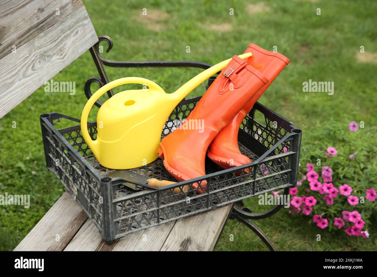 Orange rubber boots and gardening tools in crate outdoors Stock Photo ...
