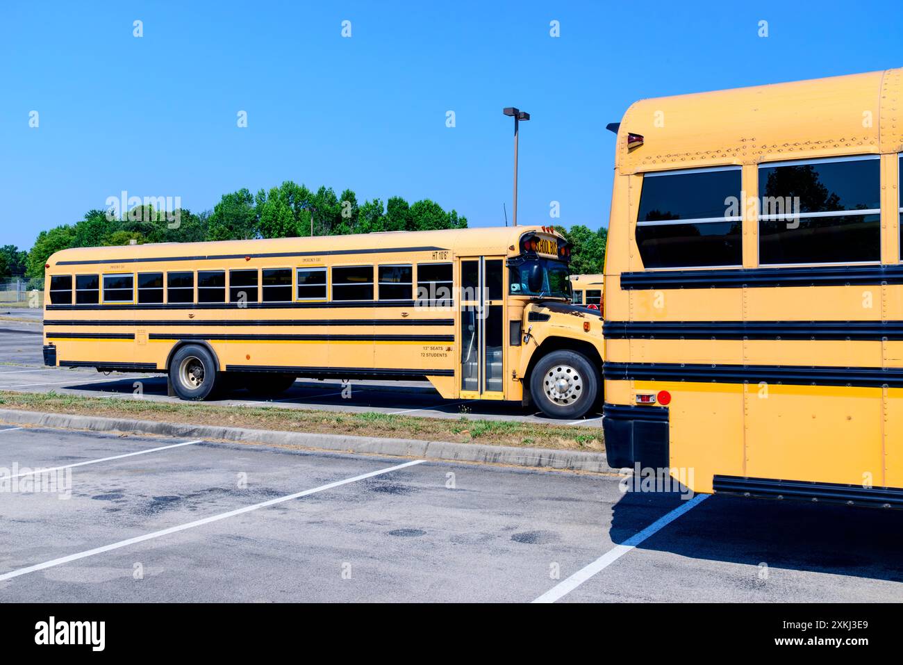 Horizontal shot of two yellow school buses parked for the summer Stock ...